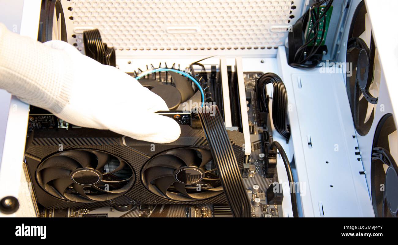 Technician repairing computer, installing video card Stock Photo - Alamy