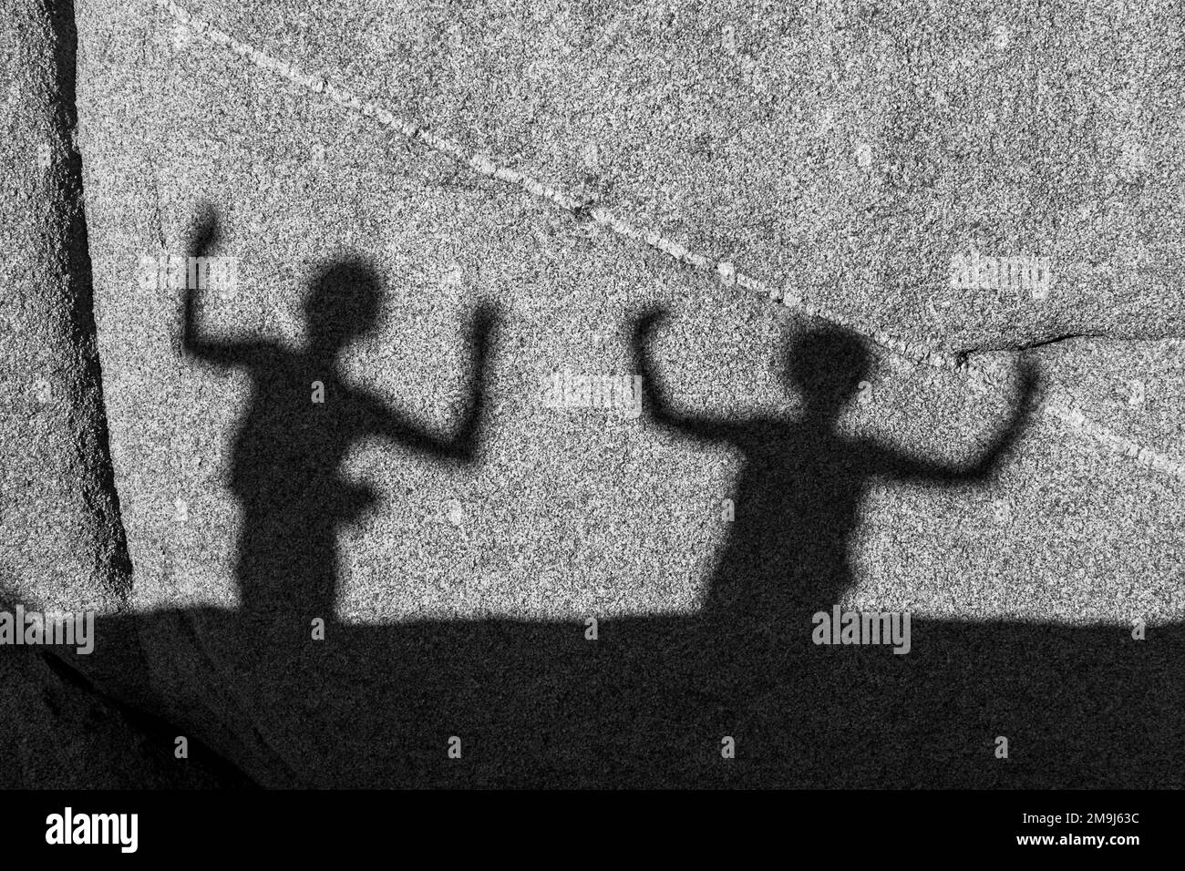 children playing with shadows on a rock in Jushua Tree National park ...
