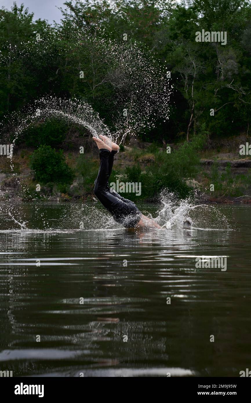 young man jumping to river, swimming into the water Stock Photo - Alamy