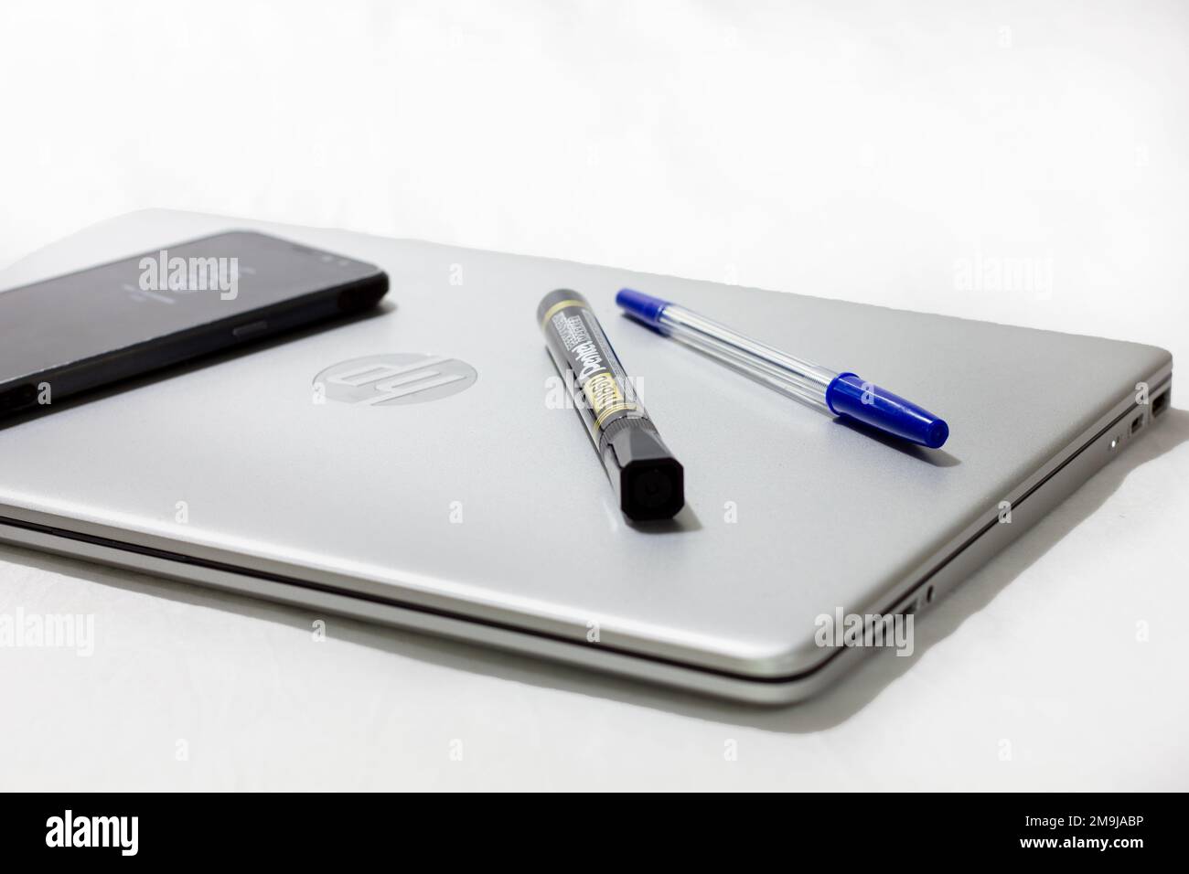 laptop, cell phone and pen on white background Stock Photo - Alamy