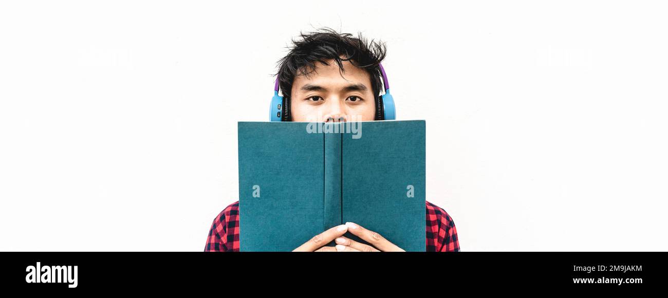 Horizontal banner with young man reading a book or listening an ...