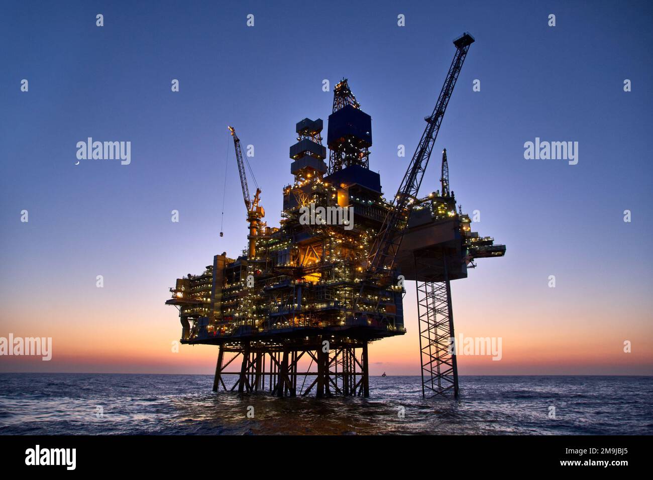 Offshore oil and gas platform in the sea at sunset Stock Photo - Alamy