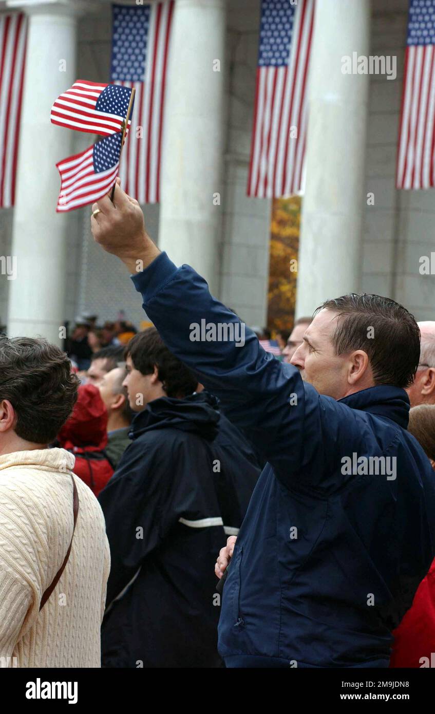 A patriotic spectator stands inside the crowded amphitheater at ...