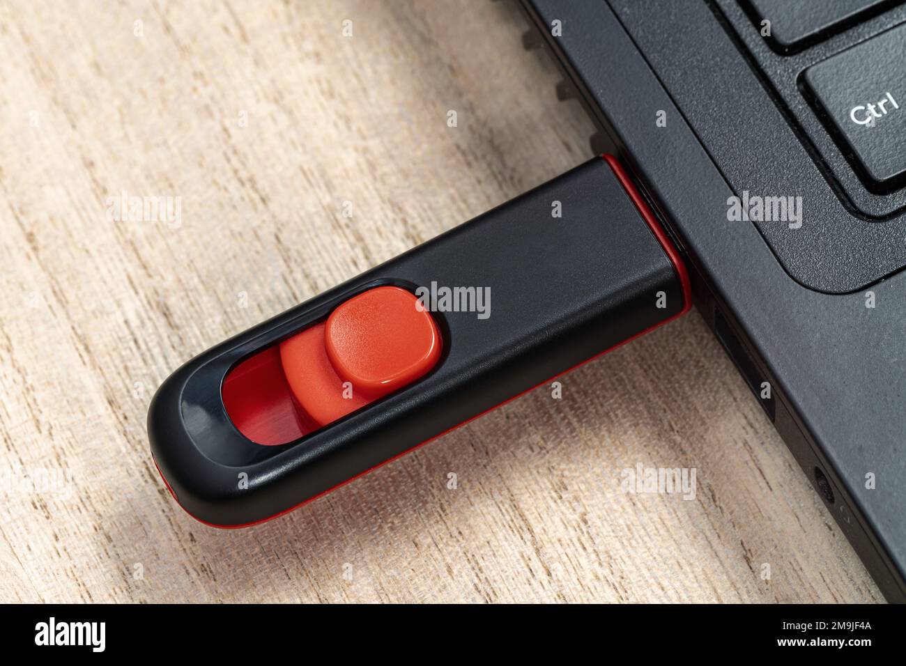 Black and red USB flash stick inserted to laptop computer's USB port ...