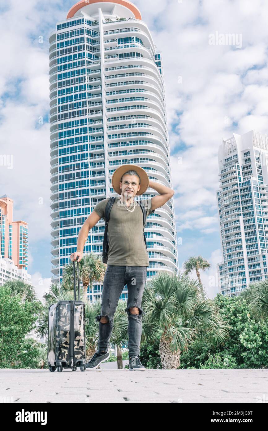 Full body portrait of smiling handsome man posing with suitcase, A ...
