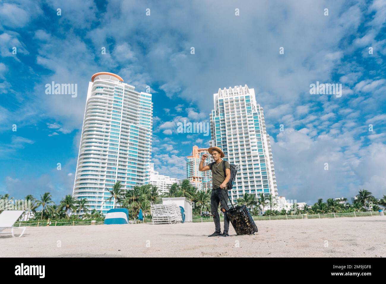Attractive young man on a sunny summer holiday, building outdoors ...