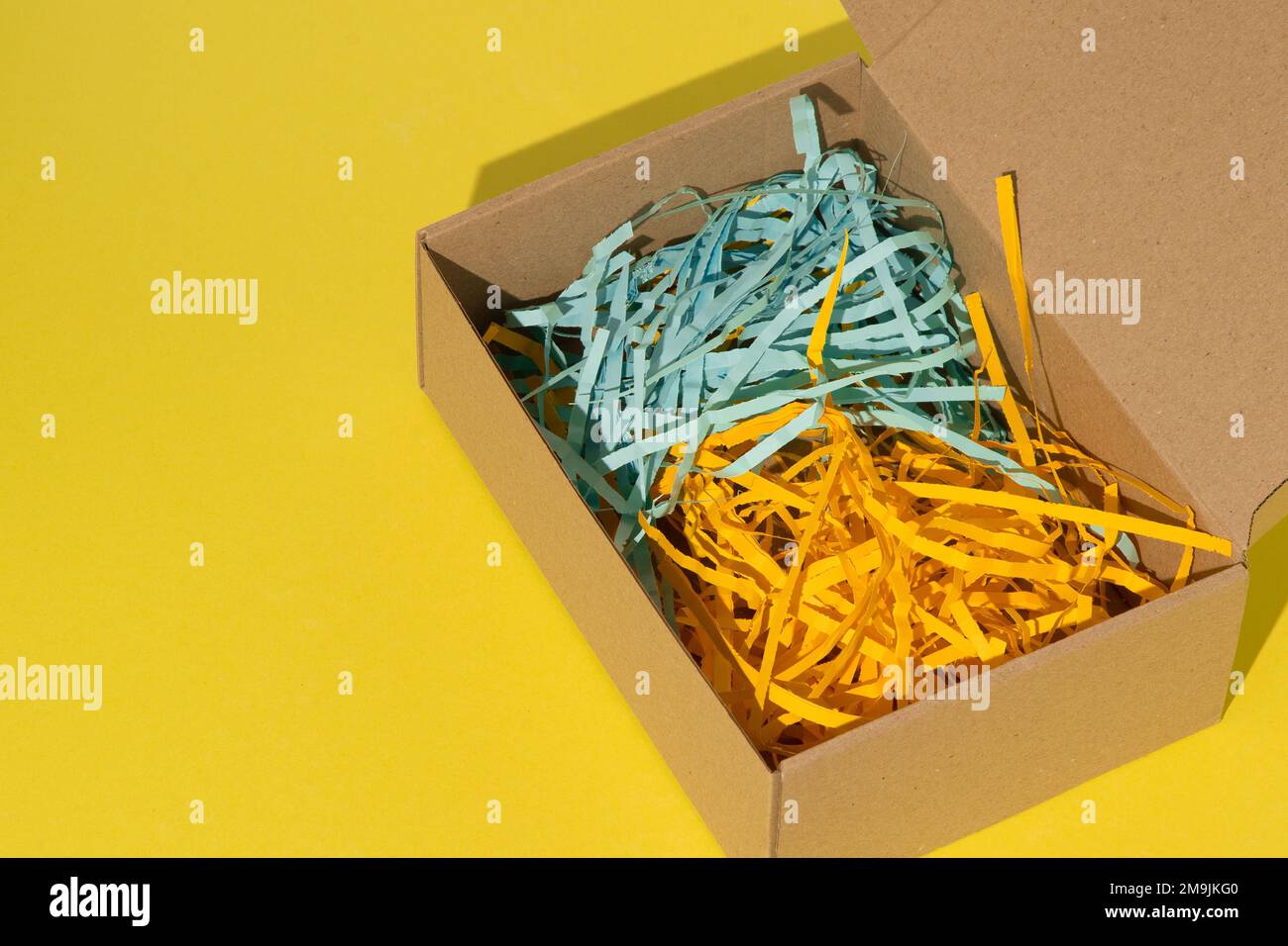 Gift wrap. Box with yellow and blue paper filling. Top view from above ...