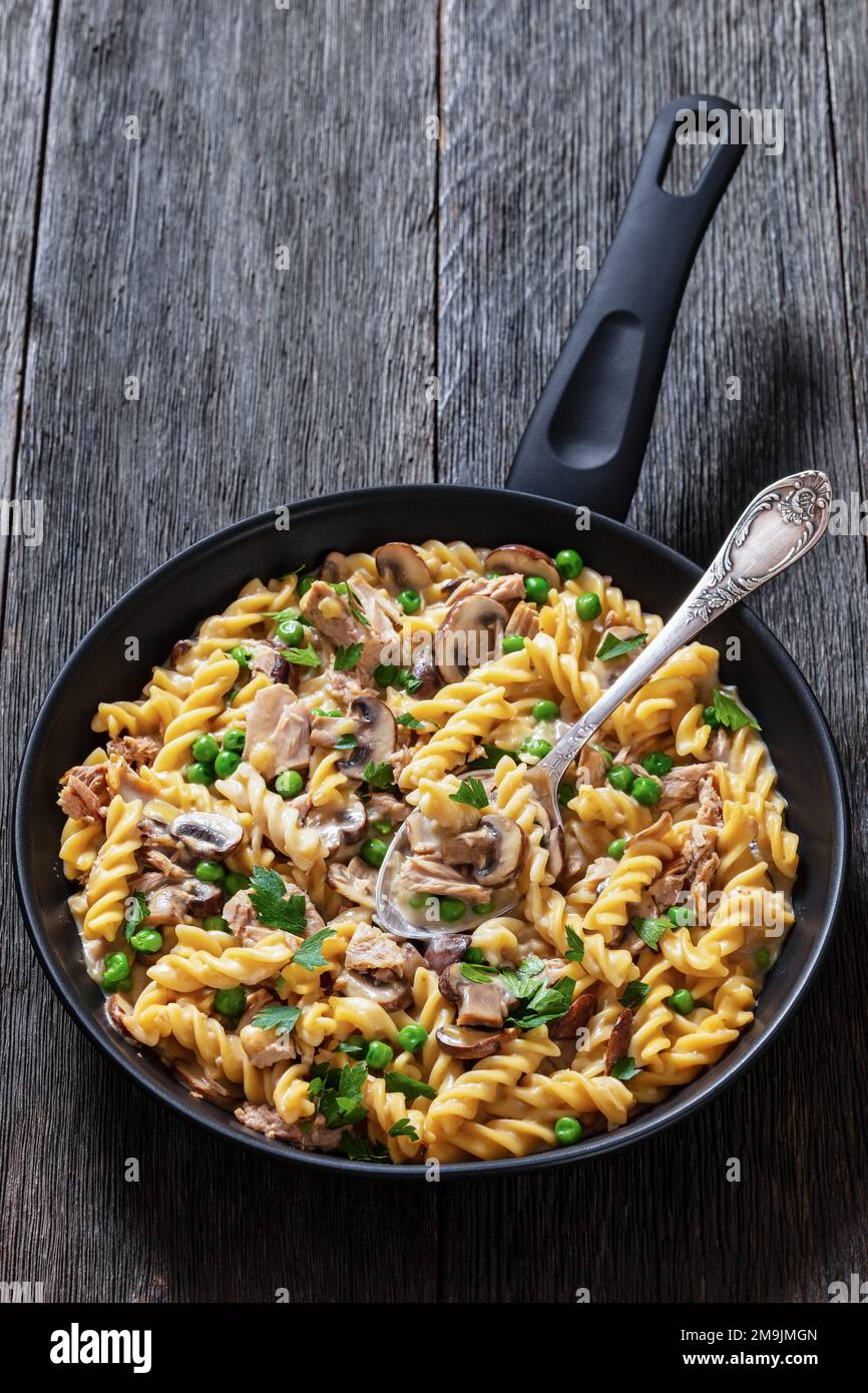 tuna mushroom green pea fusilli with creamy cheese sauce in pan on dark ...