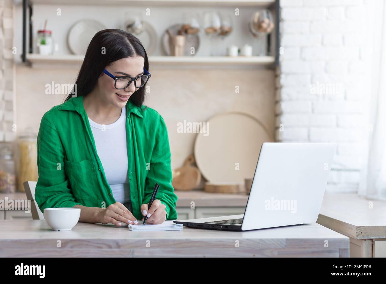 A young female student, a freelancer studies, works online, remotely at ...