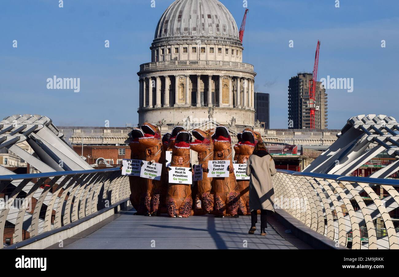 London, UK. 18th January 2023. PETA activists wearing dinosaur costumes urge people to go vegan ...