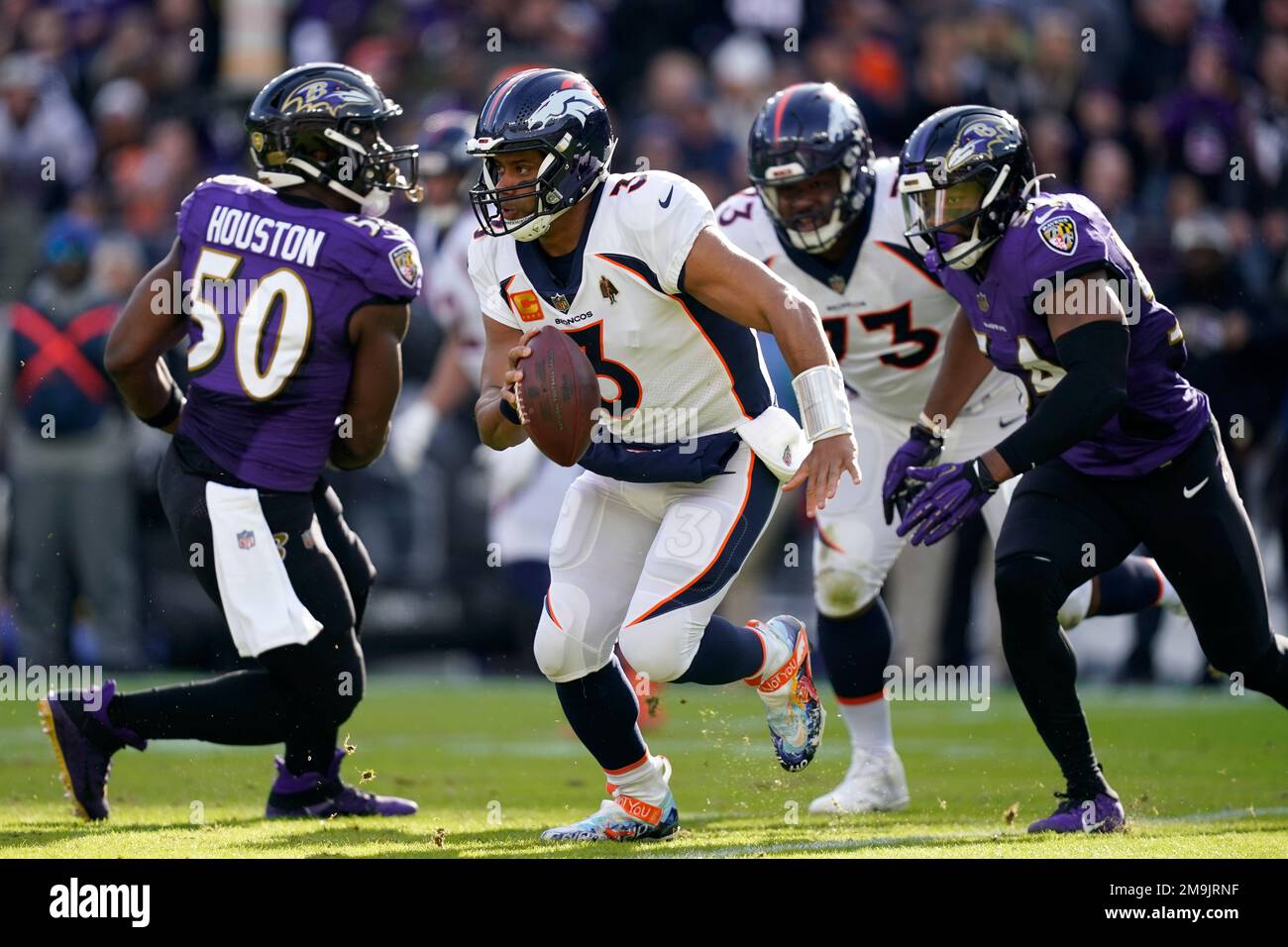 Denver Broncos quarterback Russell Wilson (3) scrambles with the ball ...