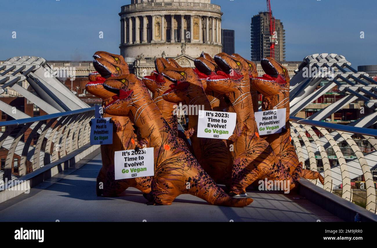 London, UK. 18th January 2023. PETA activists wearing dinosaur costumes urge people to go vegan ...