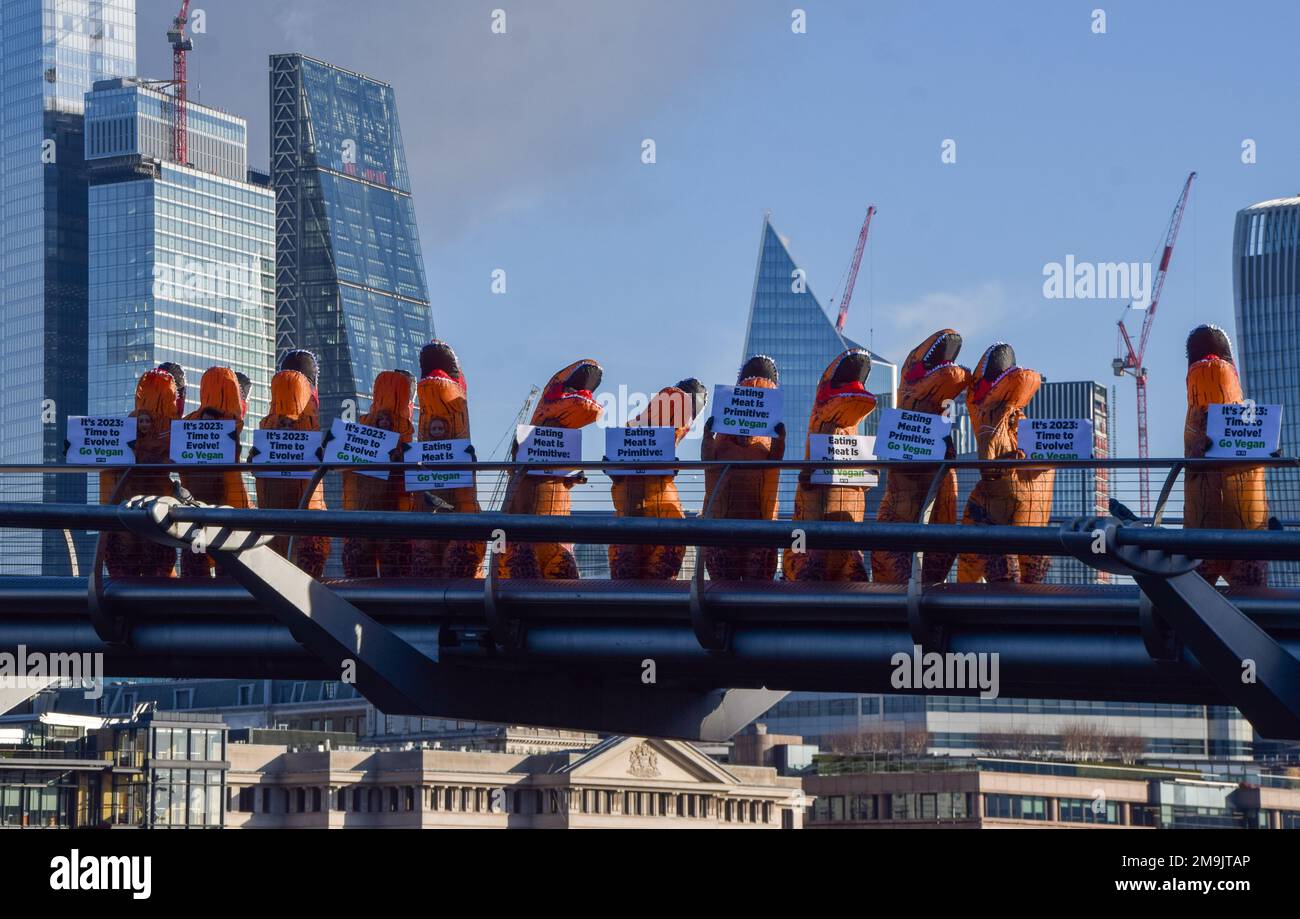 London, UK. 18th January 2023. PETA activists wearing dinosaur costumes urge people to go vegan ...