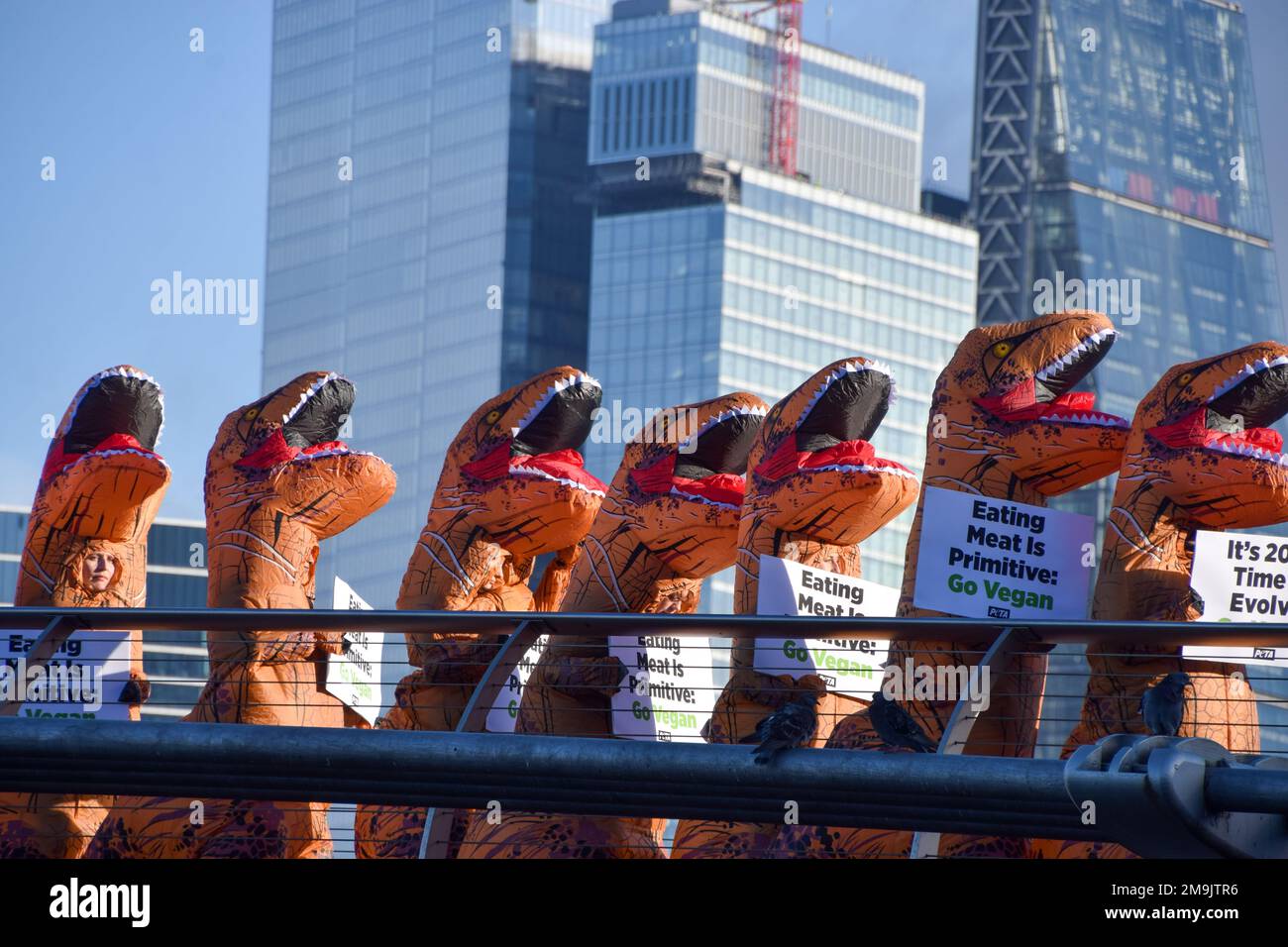London, UK. 18th January 2023. PETA activists wearing dinosaur costumes urge people to go vegan ...