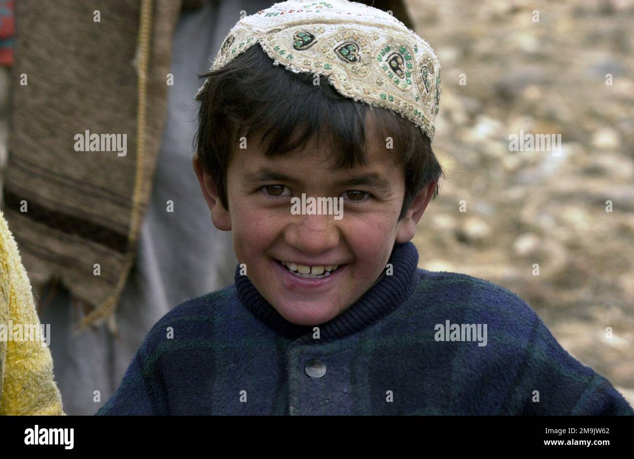 A local Afghan boy poses with a big smile for a picture at the site of a new school in the ...