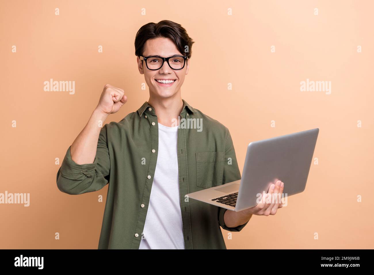 Photo of positive man use wireless netbook raise fist celebrate triumph ...