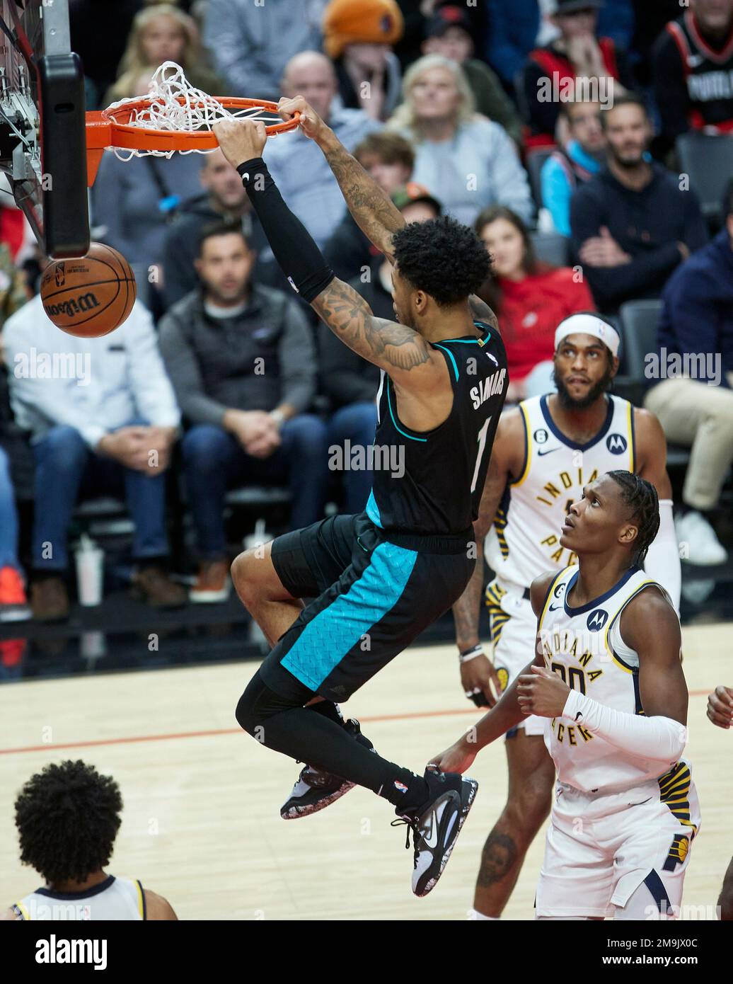 Portland Trail Blazers guard Anfernee Simons, left, dunks over Indiana ...