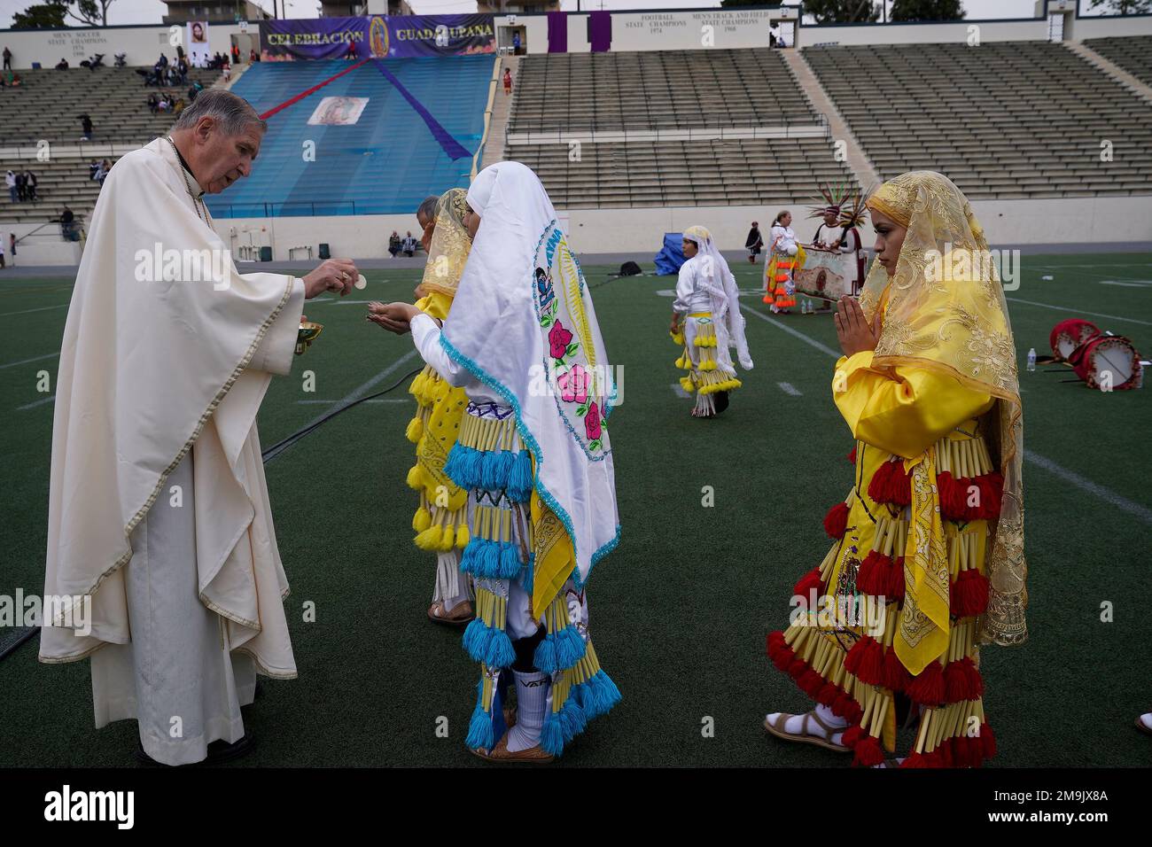 Retired Cardinal Roger Mahony helps distribute Holy Communion as ...