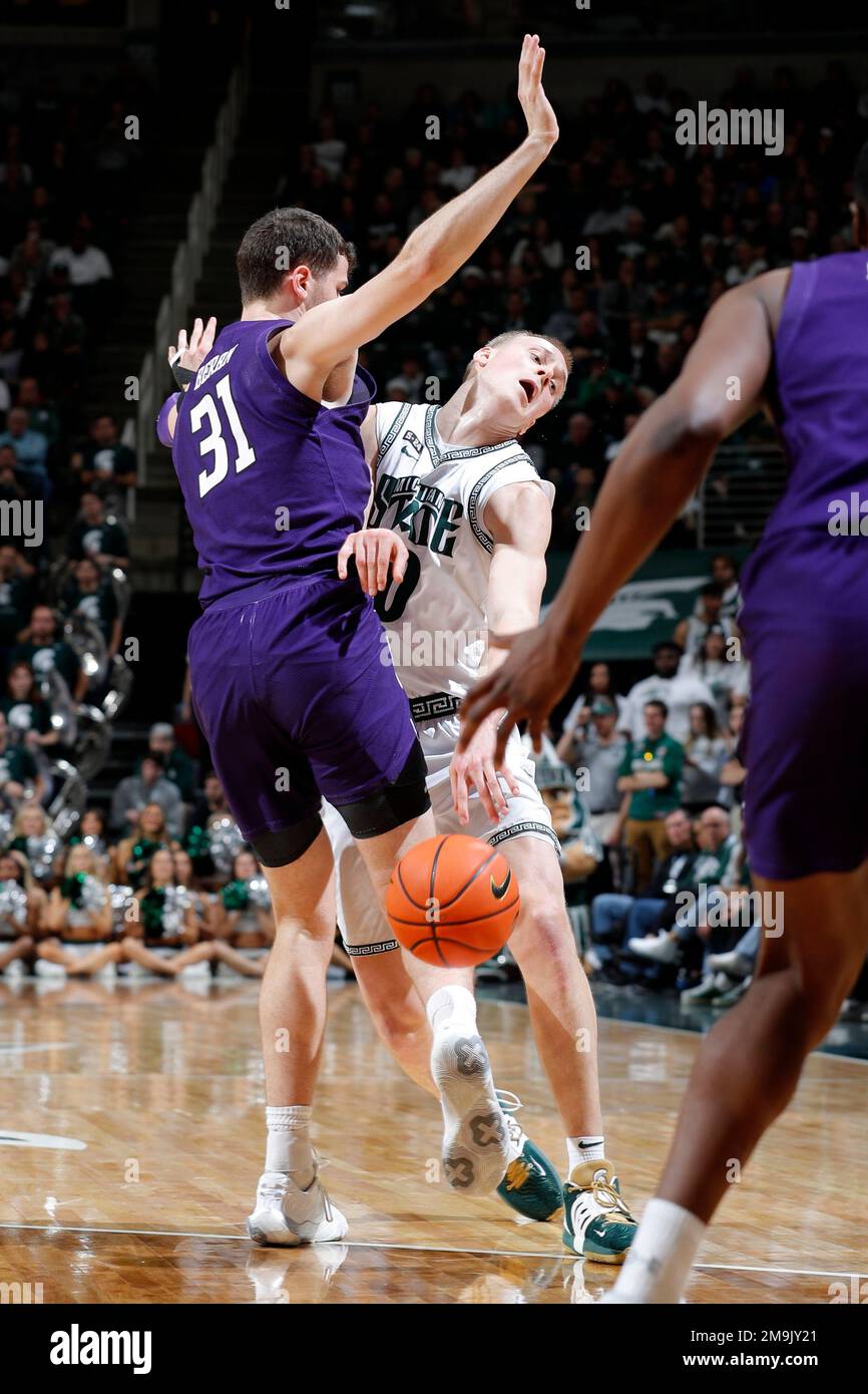 Michigan State's Joey Hauser, center, collides with Northwestern's ...