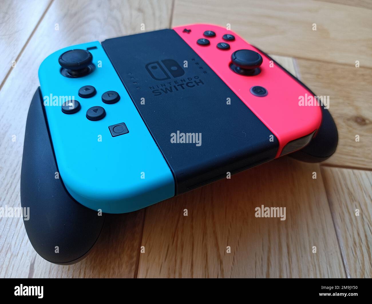 A Nintendo Switch controller on a wooden floor Stock Photo - Alamy