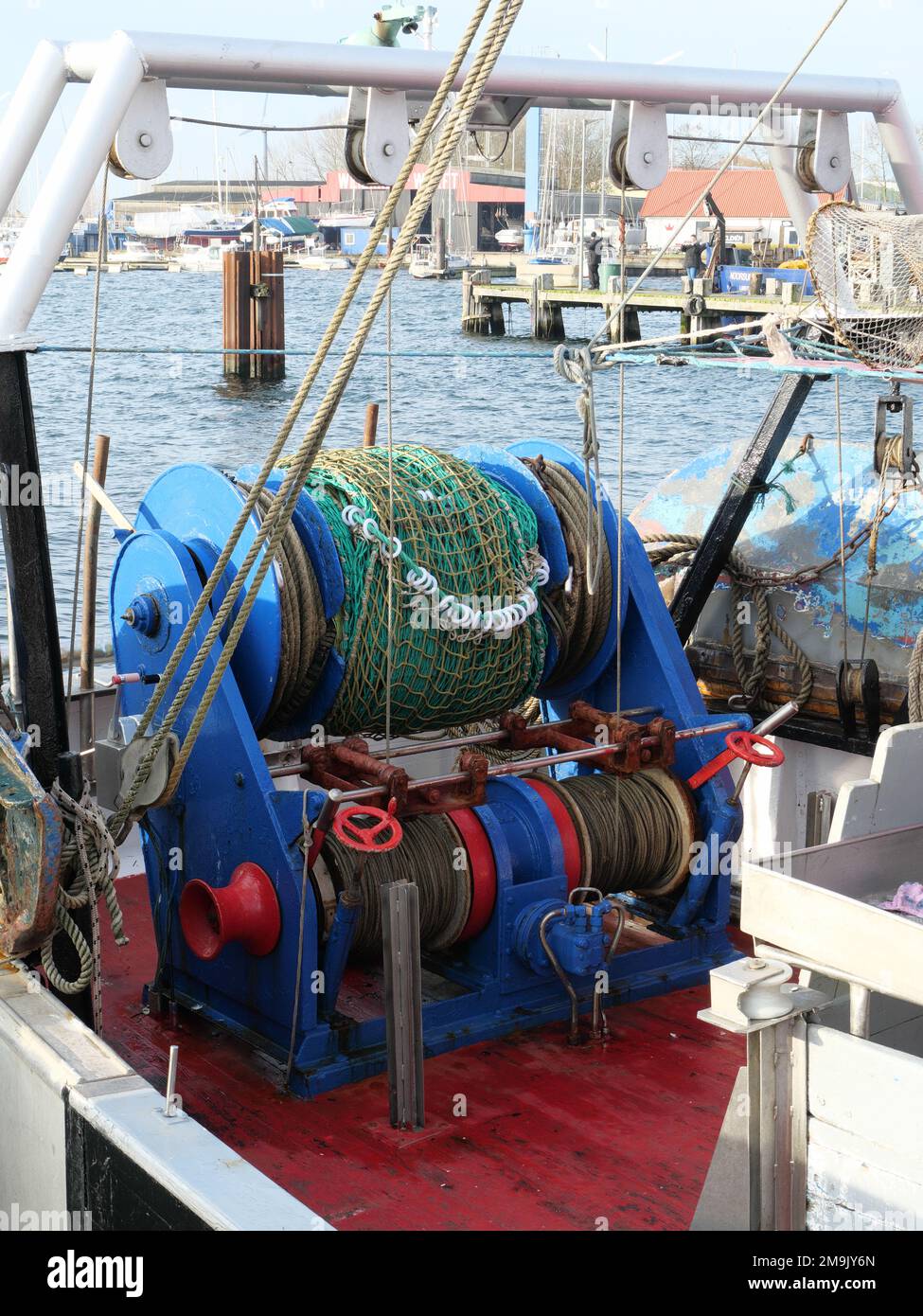 A winch for hauling in the trawl net on a fishing cutter in the harbor ...