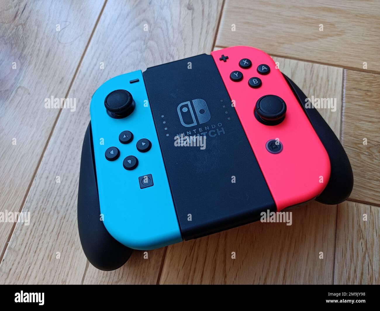 A Nintendo Switch controller on a wooden floor Stock Photo - Alamy