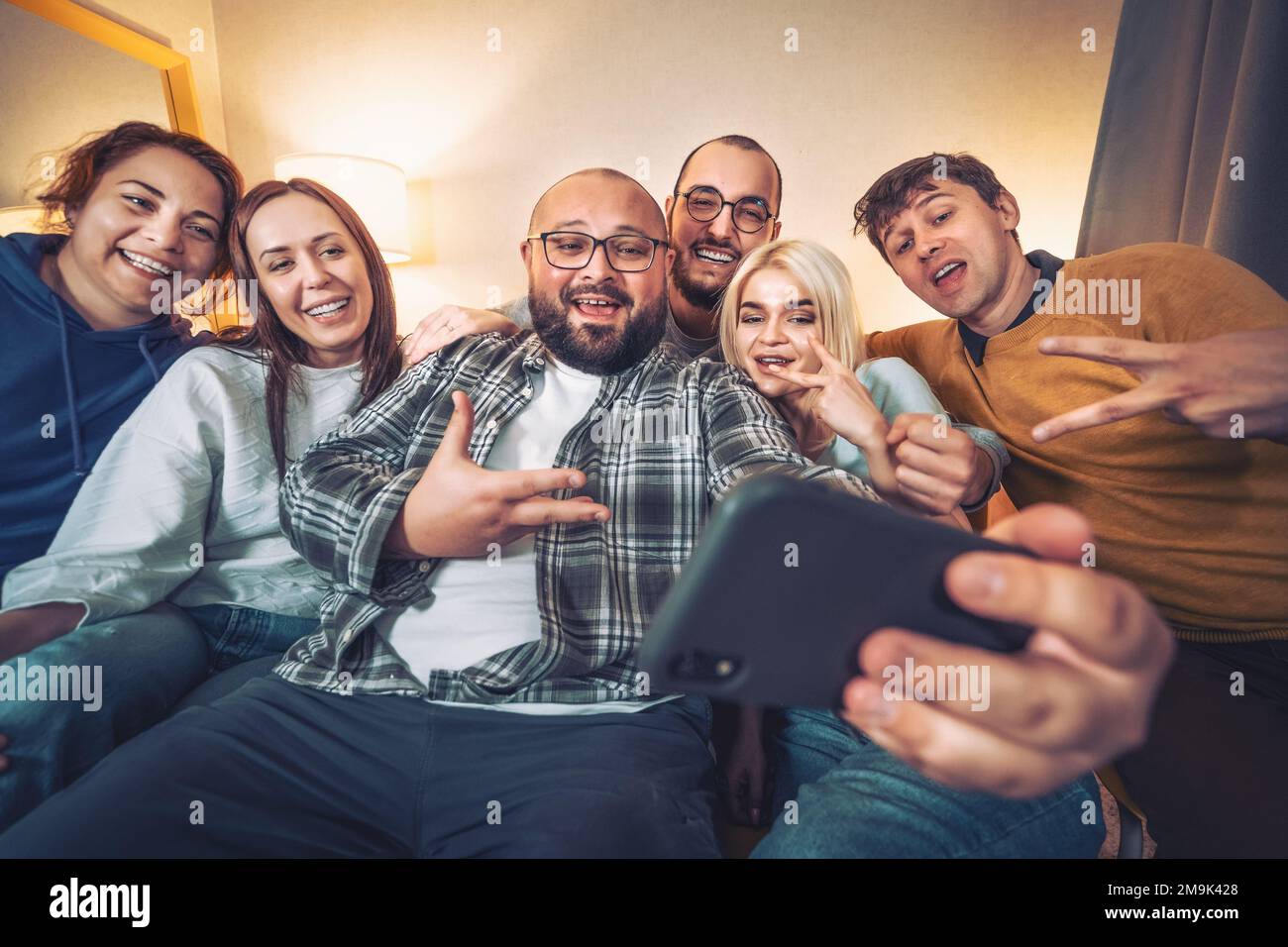 Friends at home party taking selfie, laughing, having good time. Use ...