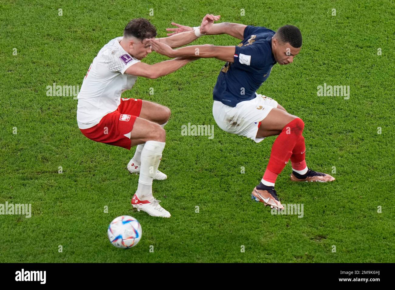 France's Kylian Mbappe, right, fights for the ball with Poland's Matty ...