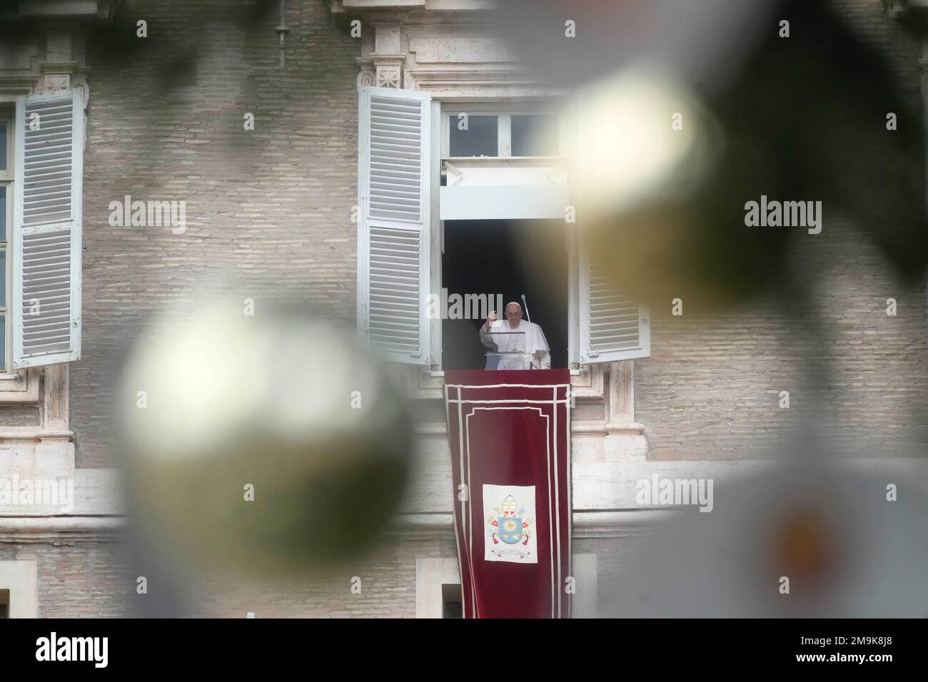 Pope Francis, framed by the branches and decorations of a Christmas ...