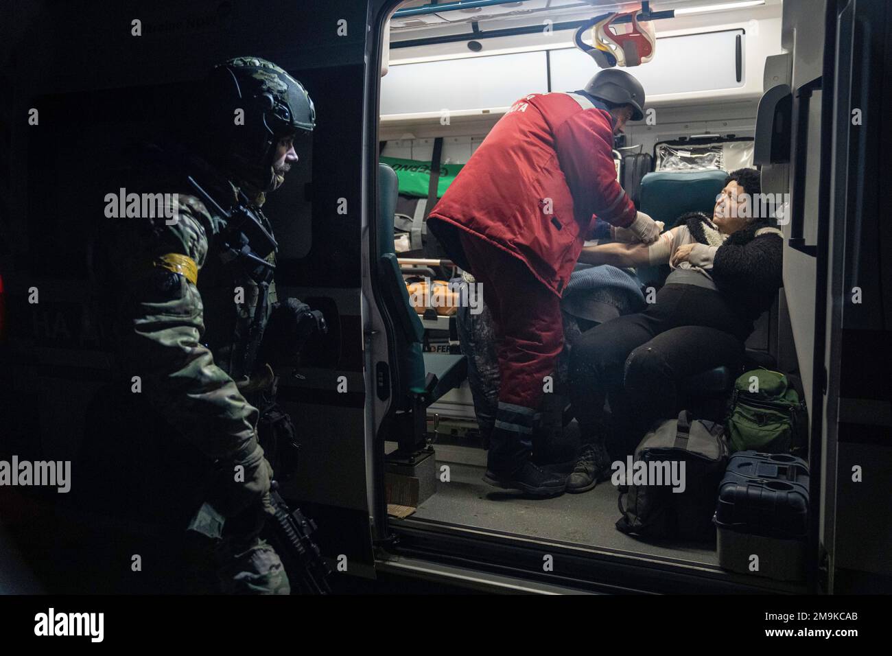 A paramedic bandages a shrapnel wound on the arm of a woman in Kherson ...