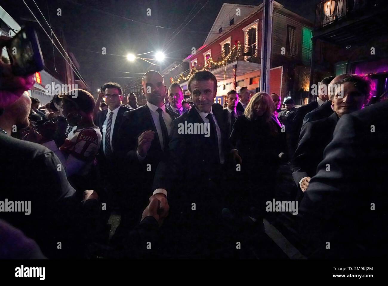 French President Emmanuel Macron shakes hands with a person as he and ...
