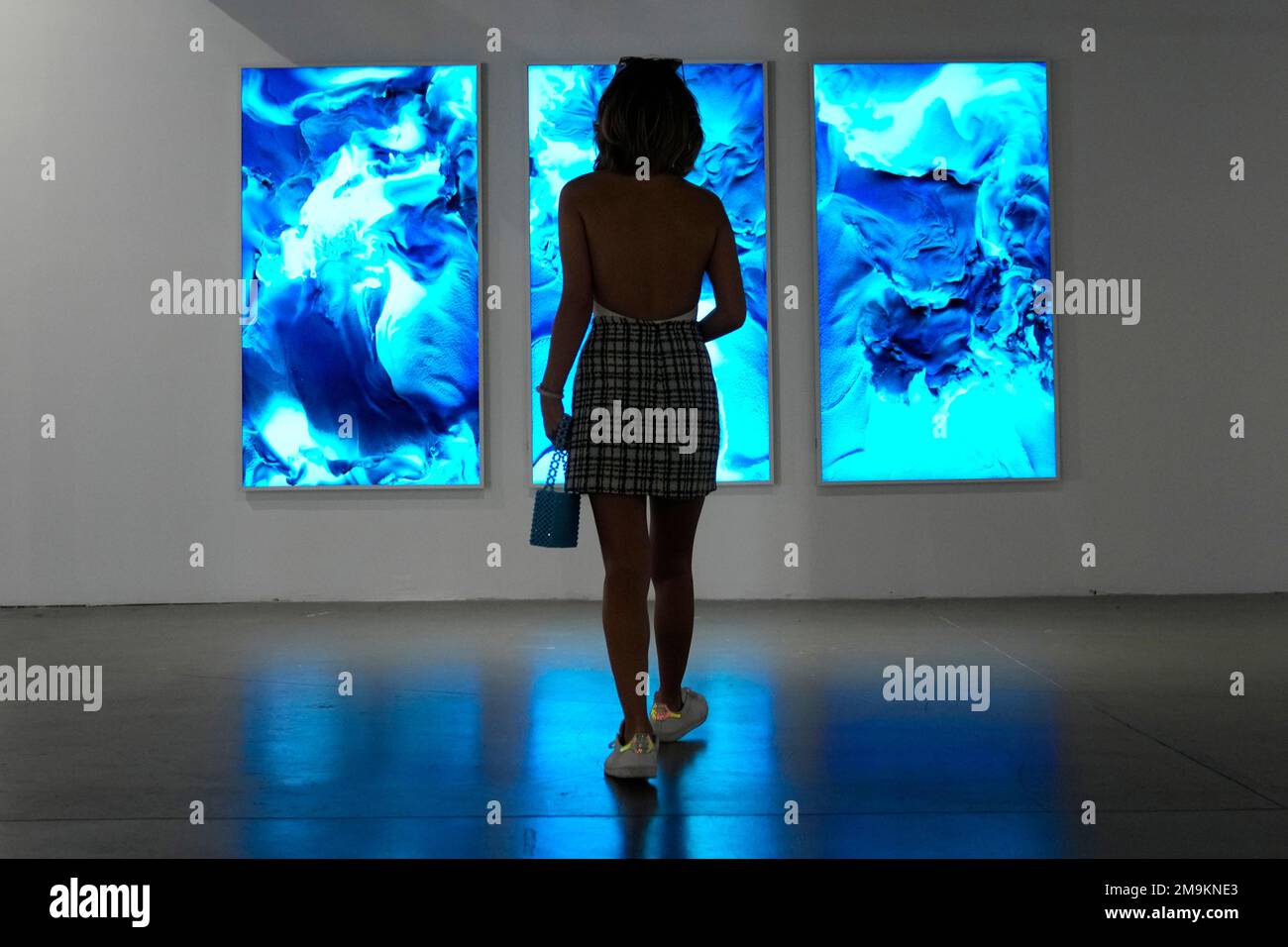 A woman looks at a high frequency radar data painting by artist Refik ...