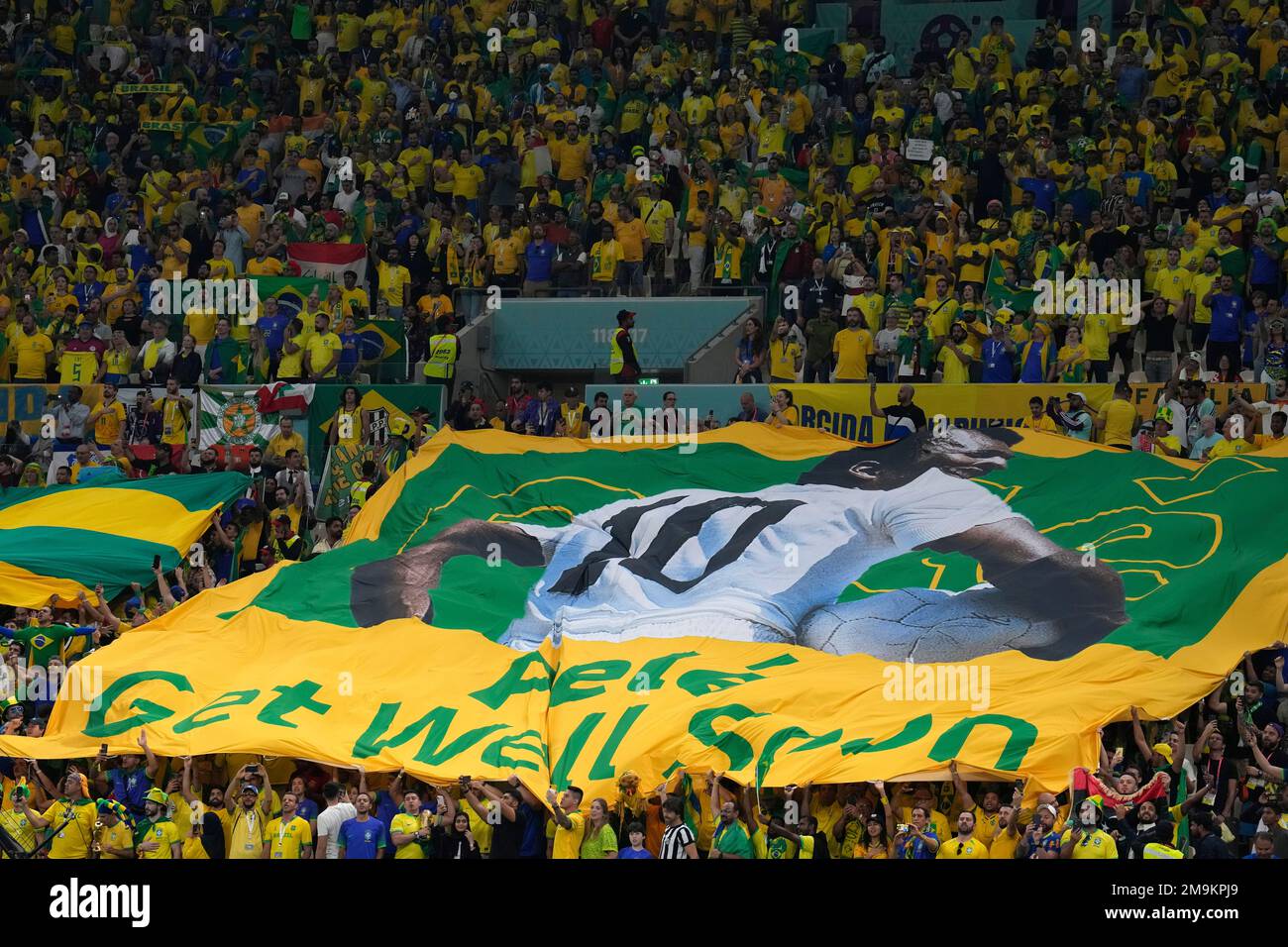 Brazilian fans hold a giant Brazilian flag with picture of former ...