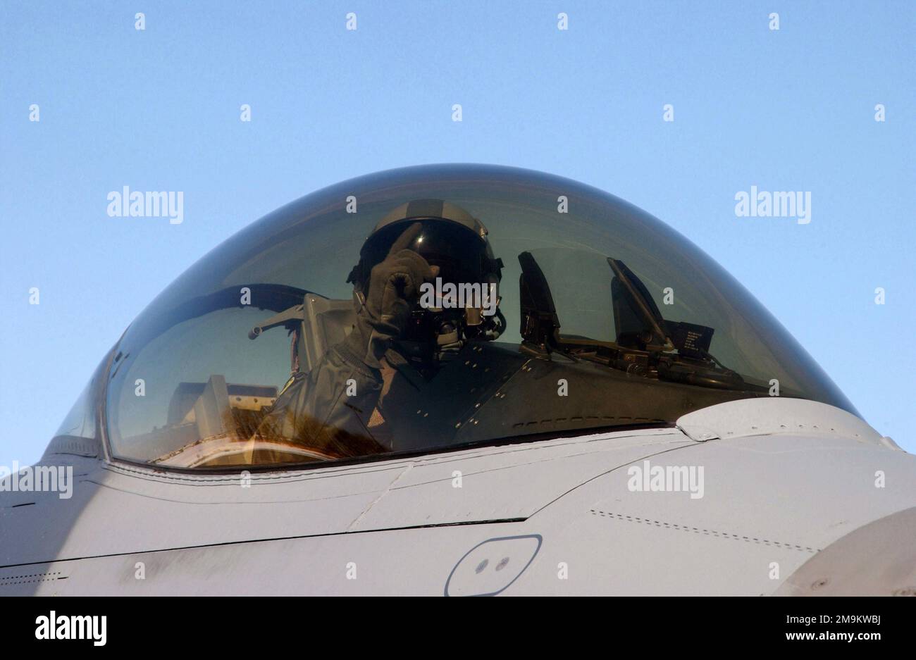 A pilot motions to his crew chief from his cockpit as he prepares for ...