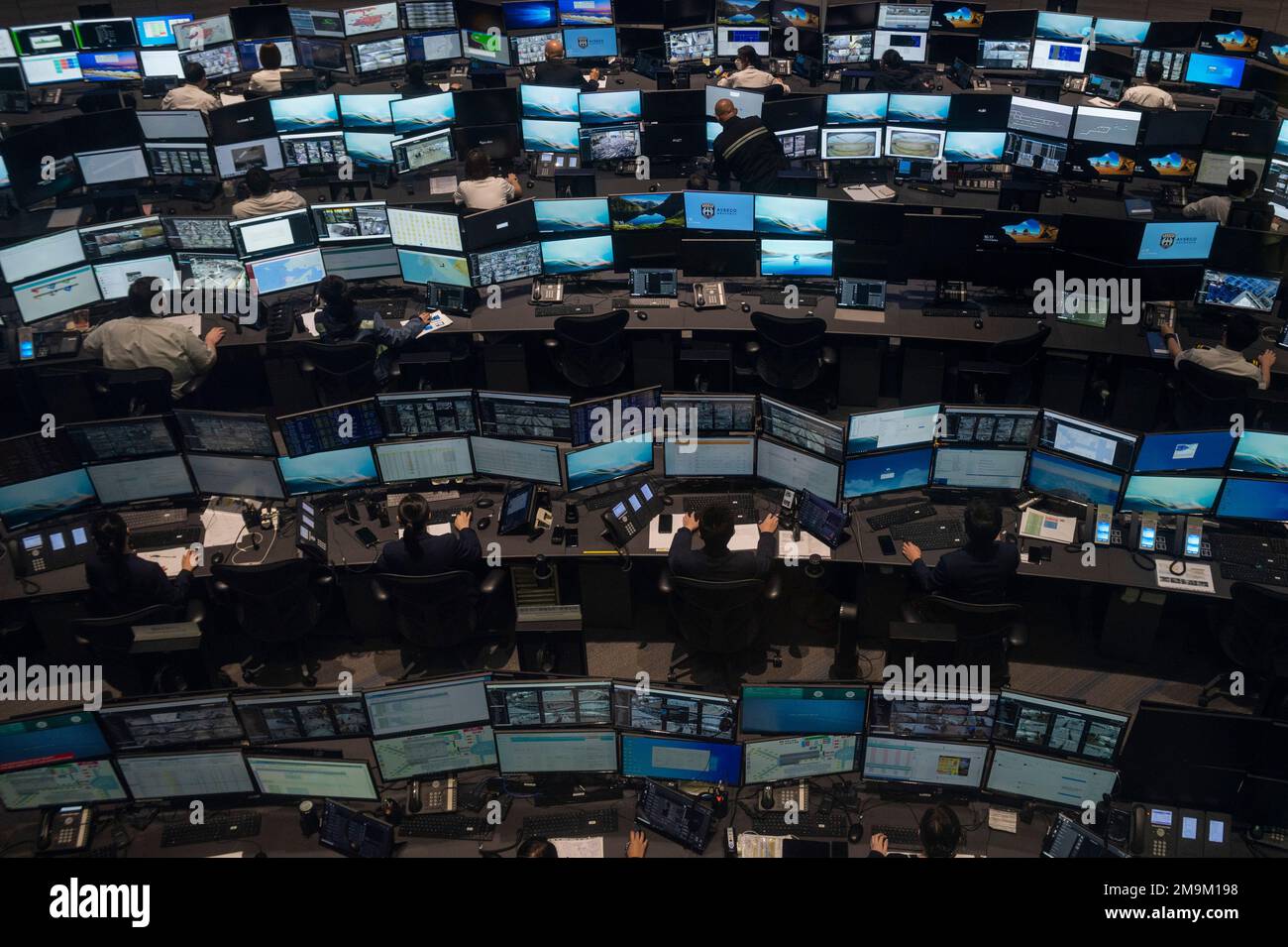 Workers monitor displays at the Integrated Airport Center at Hong Kong ...