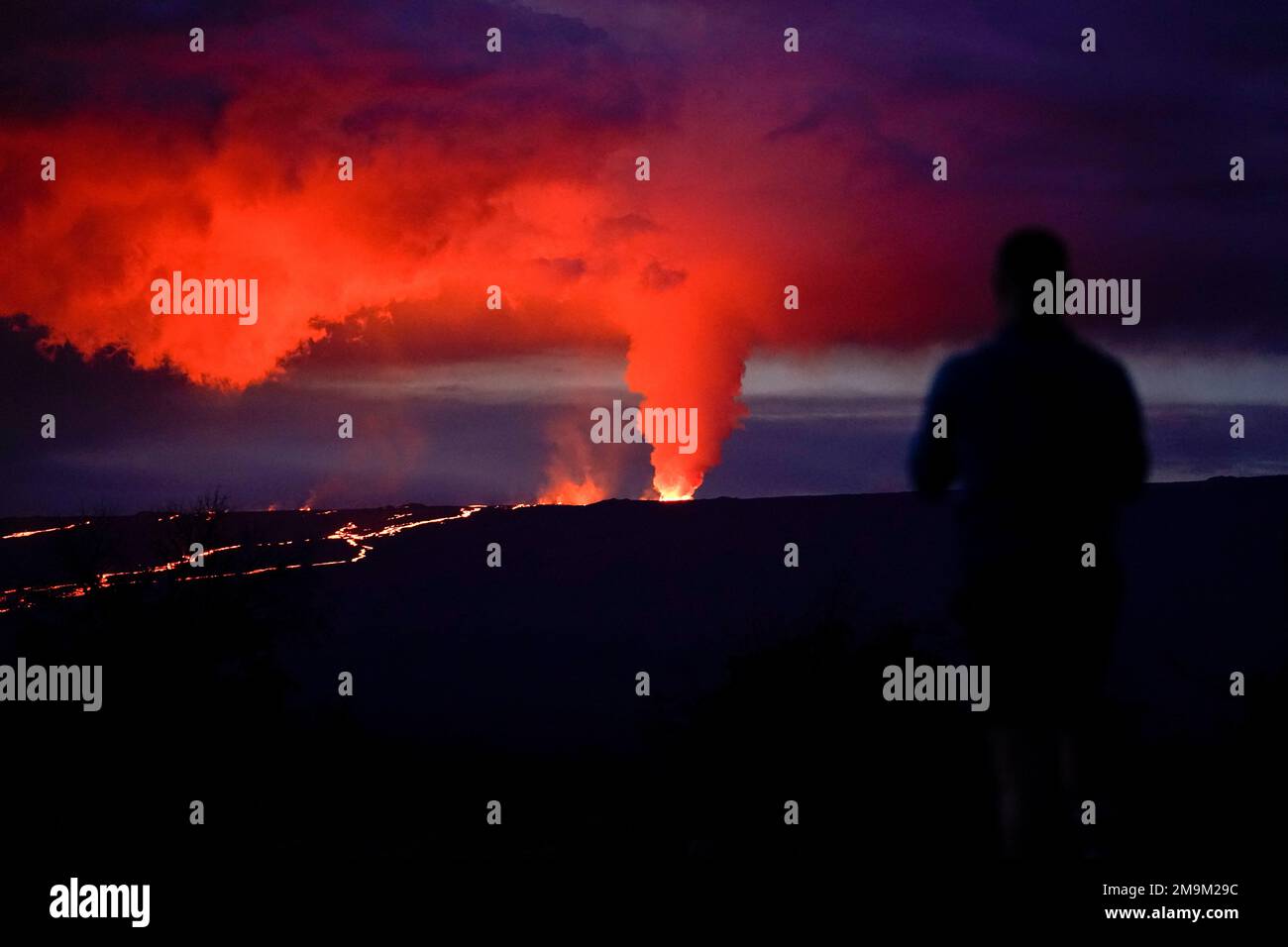 A man watches as lava erupts from Hawaii's Mauna Loa volcano Wednesday ...