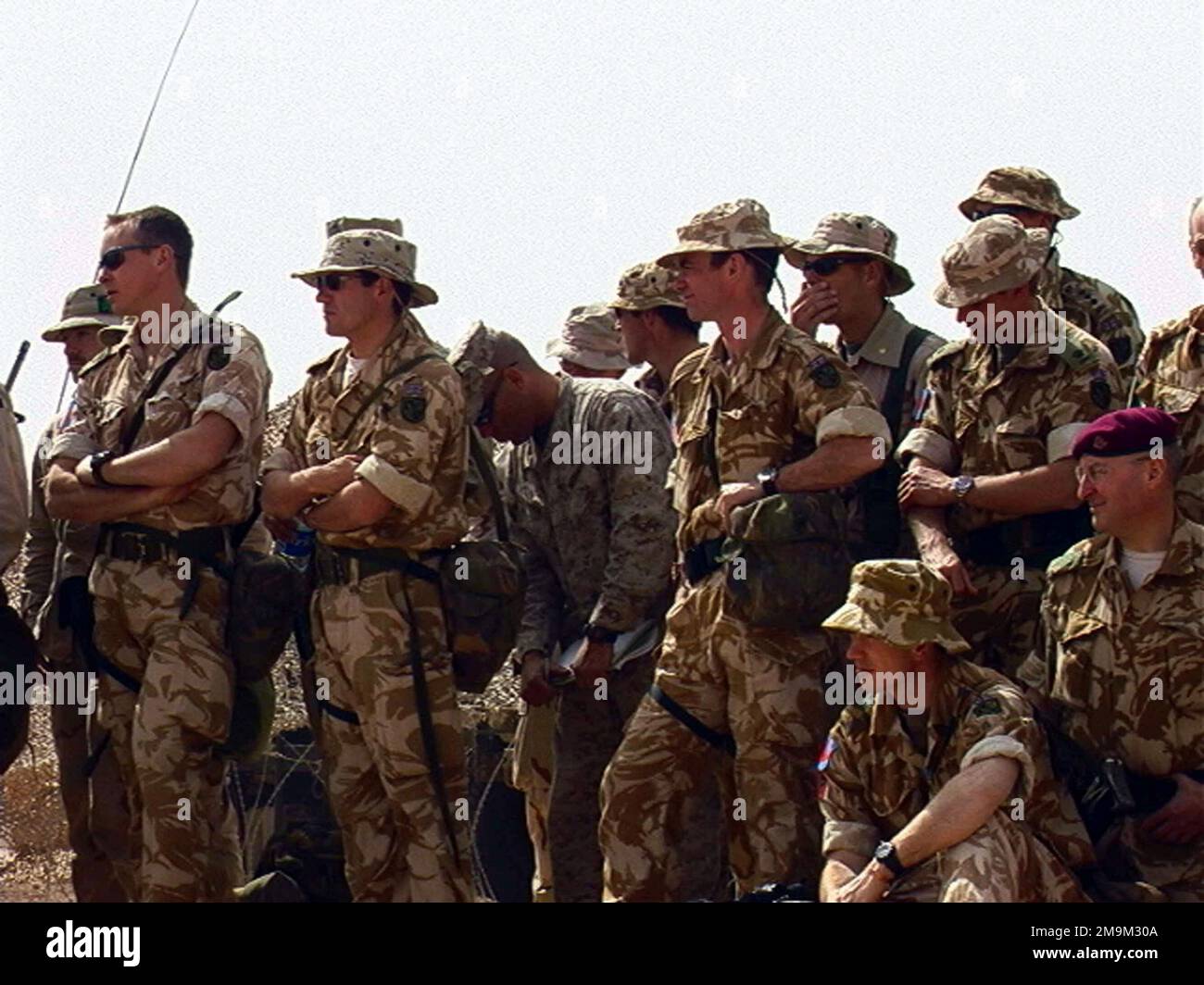 Combined British forces and US Marine Corps (USMC) Marines watch a sand ...