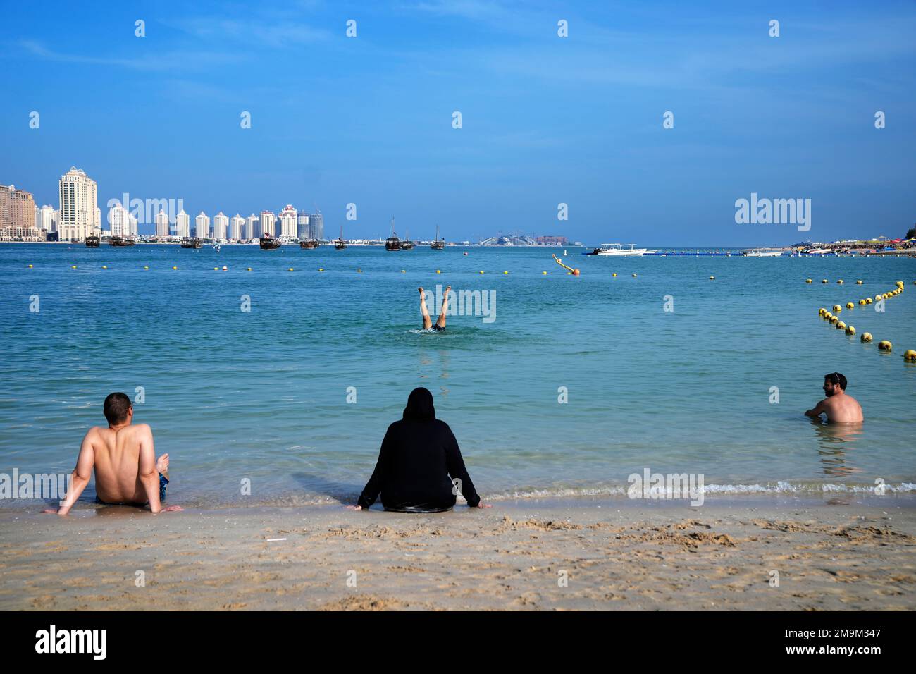 People sit and swim at Katara Beach, in Doha, Qatar, Thursday, Dec. 1, 2022. (AP Photo/Jorge ...