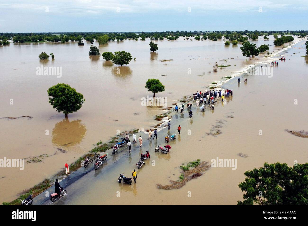 Peole walk through floodwaters after heavy rainfall in Hadeja, Nigeria ...