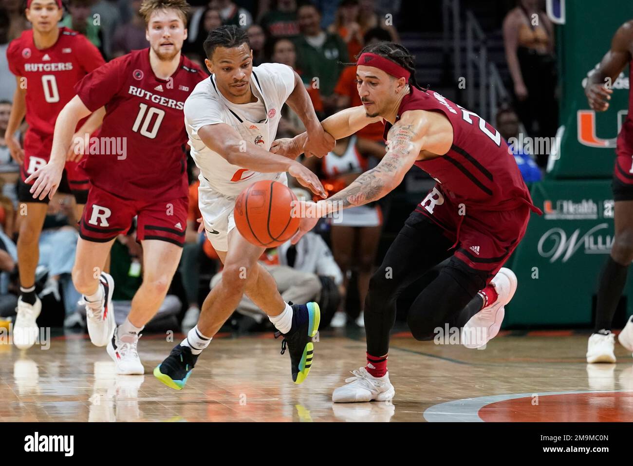 Miami guard Isaiah Wong (2) and Rutgers Caleb McConnell (22) go after ...