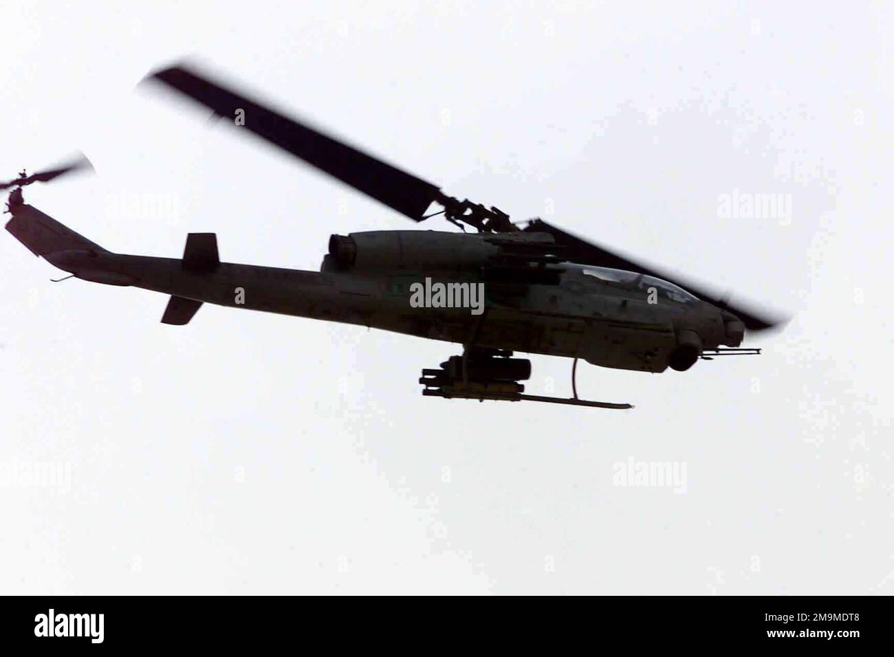 A US Marine Corps (USMC) AH-1W Super Cobra flies over an 11th Marines ...