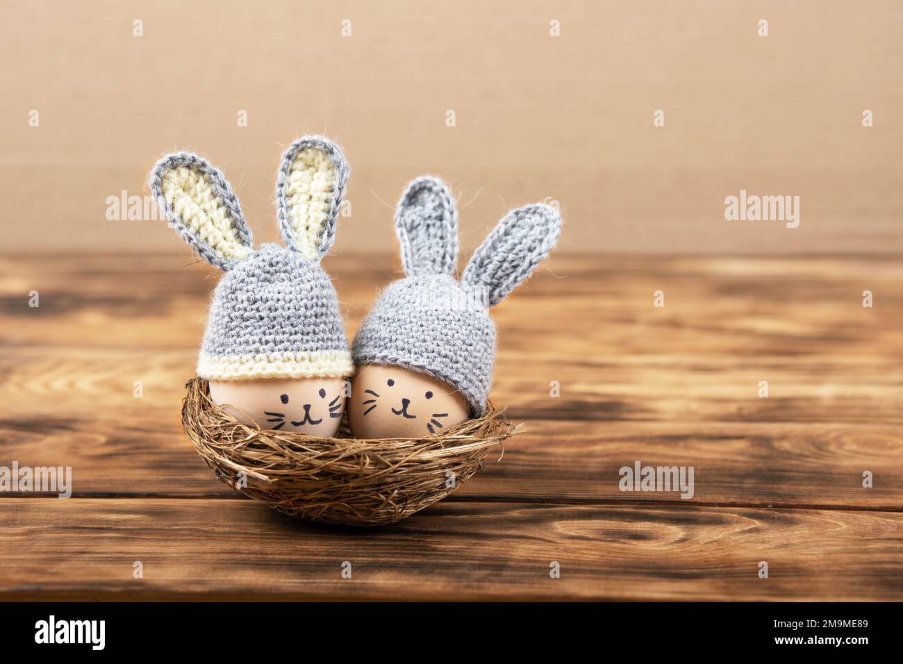 Two Easter eggs with funny faces and gray crocheted hats with bunny ...