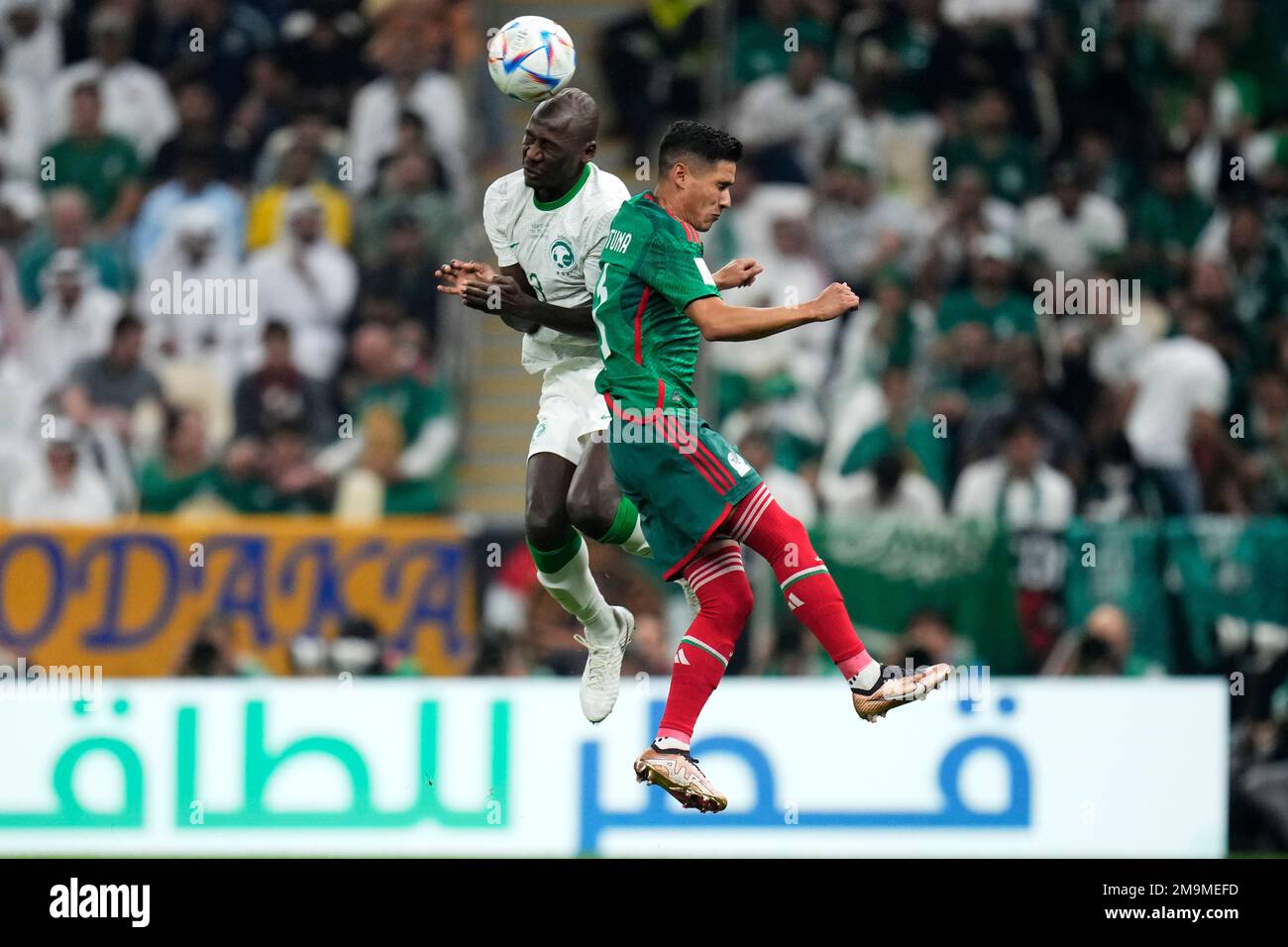 Saudi Arabia's Abdullah Madu, left, challenges Mexico's Uriel Antuna ...