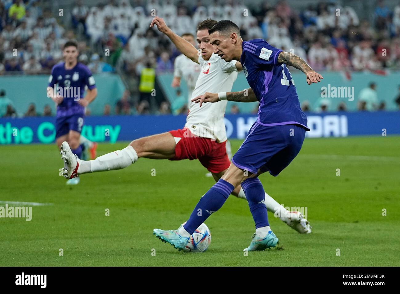 Poland's Matty Cash, background, tries to stop Argentina's Angel Di ...