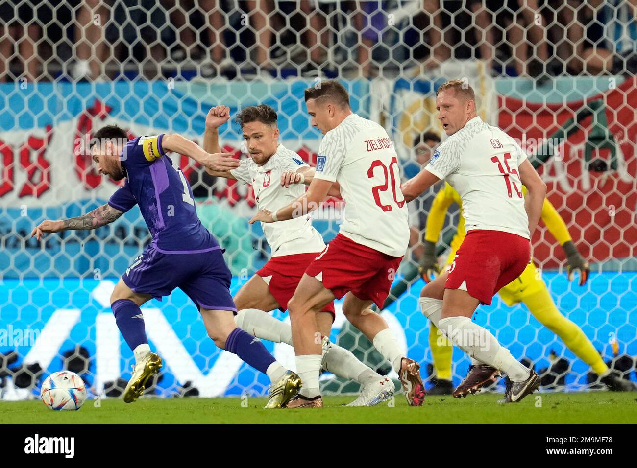 Argentina's Lionel Messi, left, tries to dribble past Poland defenders ...