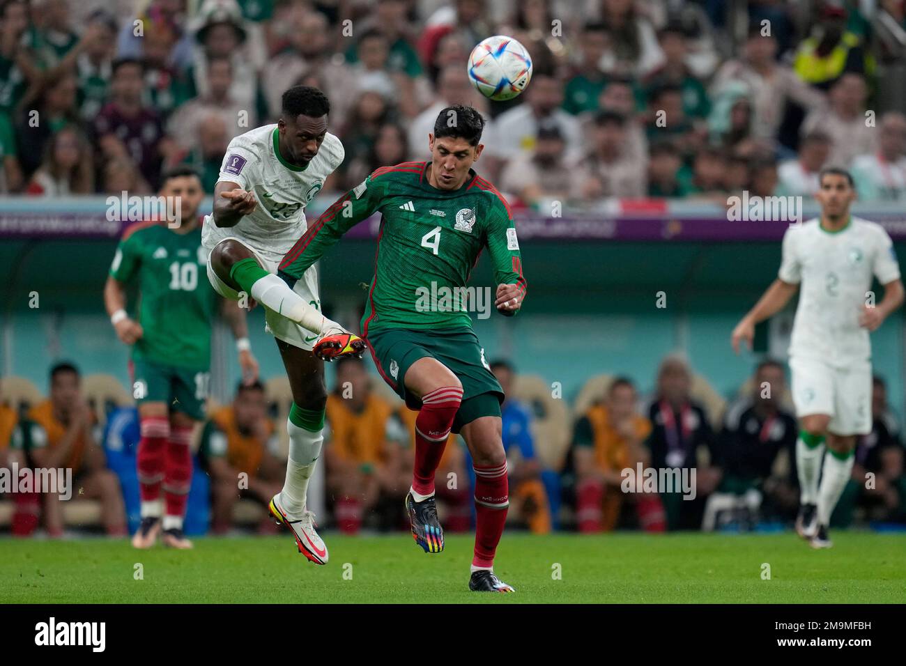 Saudi Arabia's Mohamed Kanno, left, clears the ball away from Mexico's ...