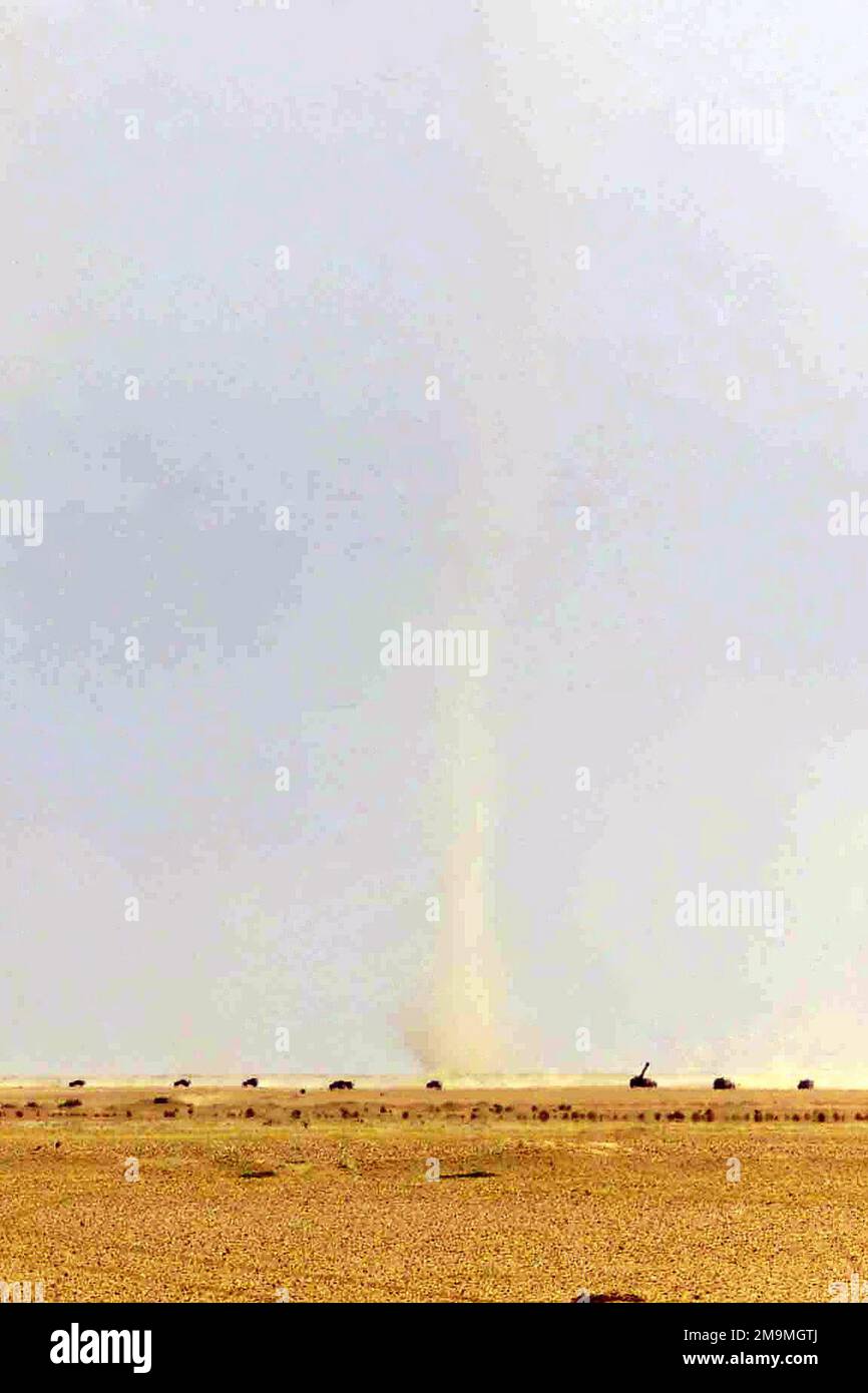 A dust devil moves along the highway as US Marine Corps (USMC) Marines ...