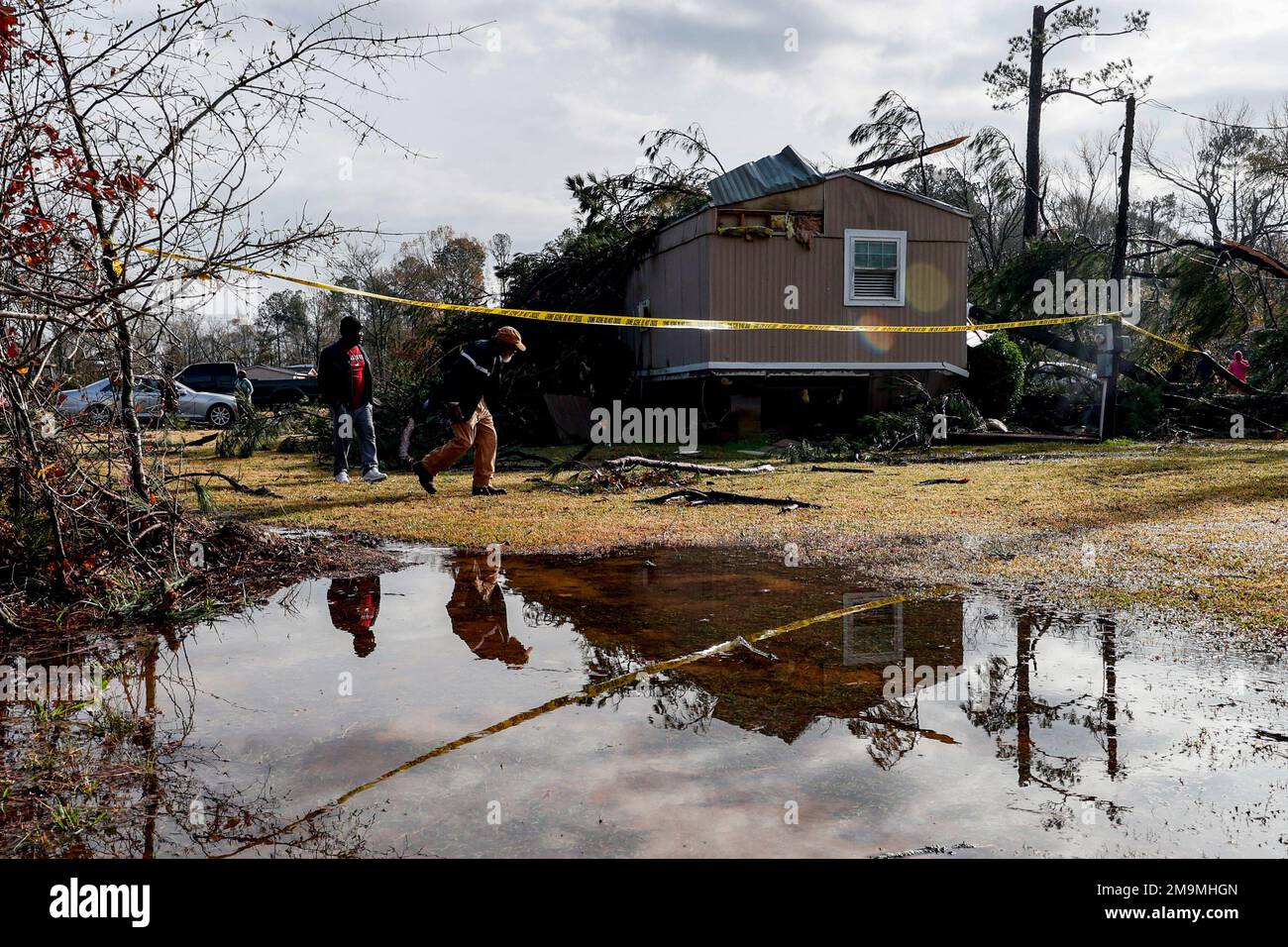 Friends and family survey damage to a house from a possible tornado ...