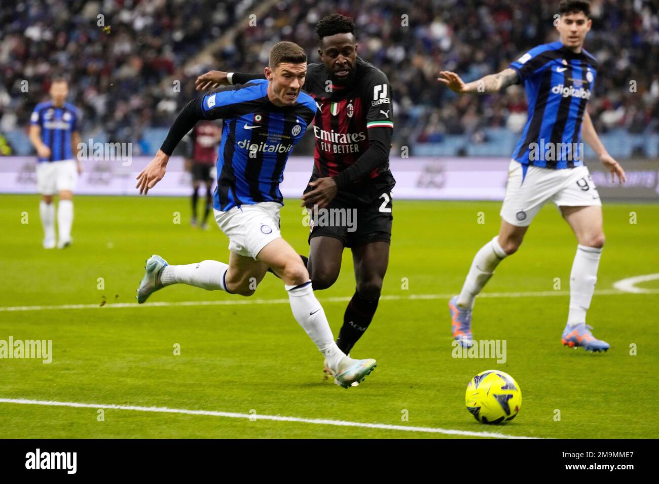 Inter Milan's Robin Gosens, left, challenges for the ball with AC Milan ...