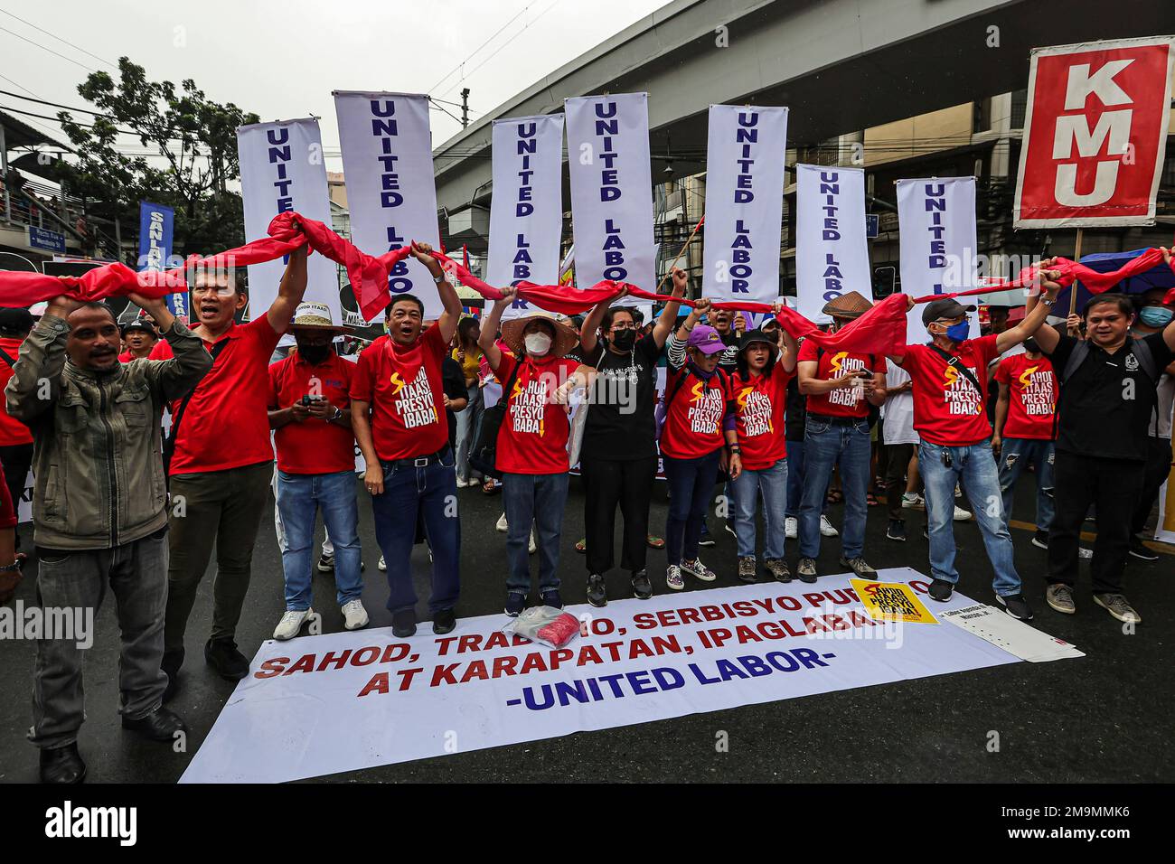 Labor leaders hold a symbolic red cloth as a sign of unity among labor ...
